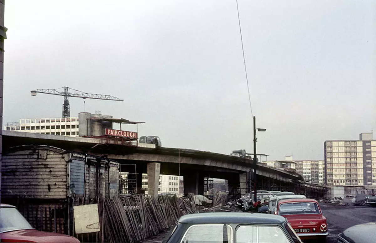 Bahagian bertingkat Jalan Mancunian sedang dalam pembinaan pada tahun 1966. Menara Bangunan Faraday UMIST, yang juga dalam pembinaan, boleh dilihat menjulang melepasi jejambat di sebelah kiri gambar.